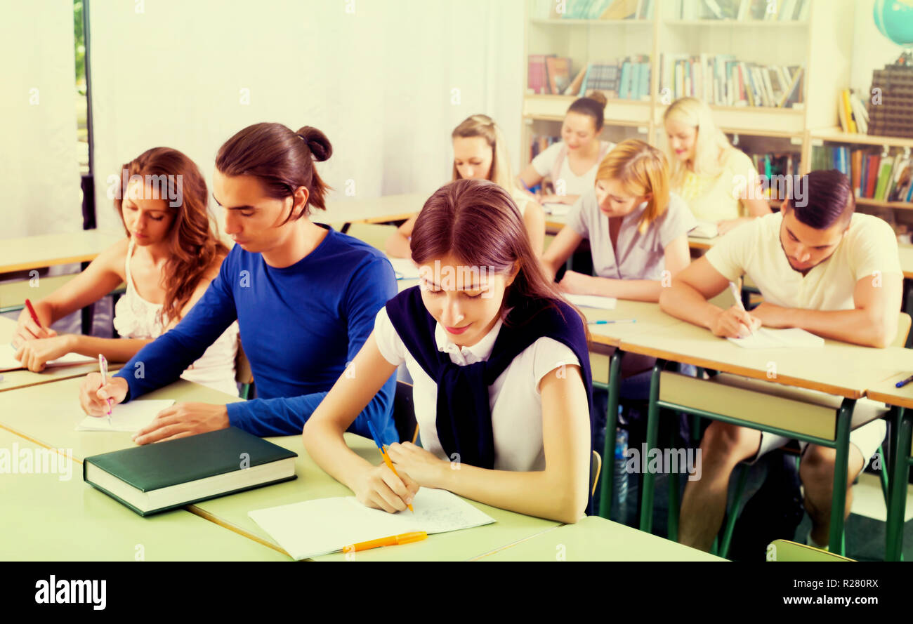 Young student listening attentively during lecture in the classroom ...