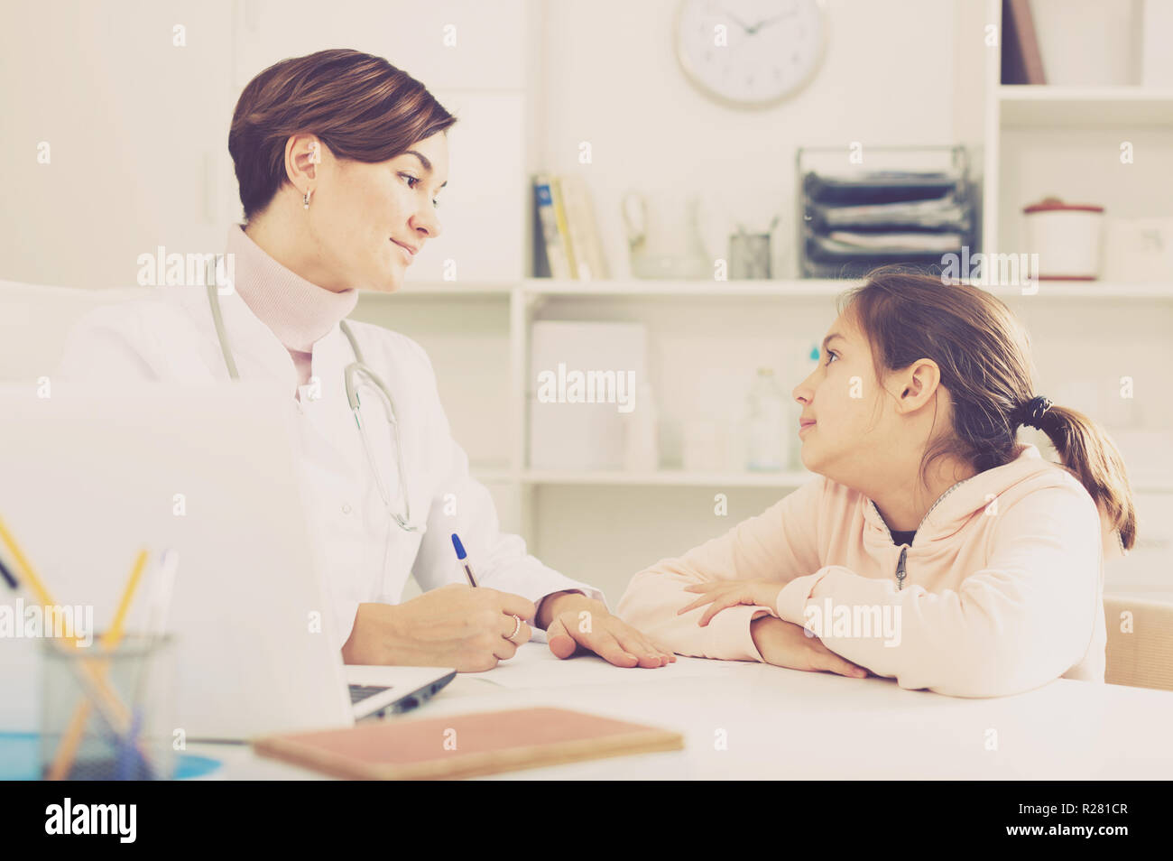 Therapist fills patient card according to teenage girl about her health ...