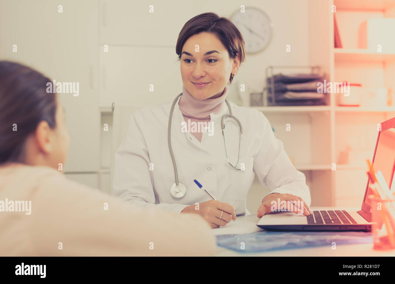 Therapist fills patient card according to teenage girl about her health ...