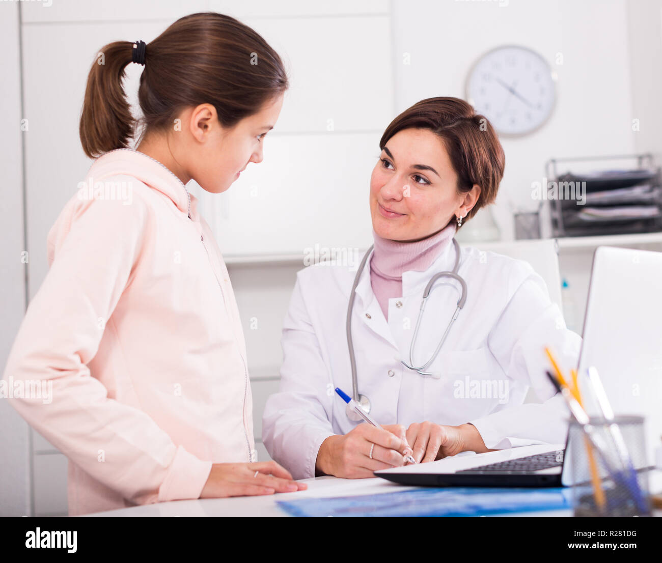 Therapist fills patient card according to teenage girl about her health ...