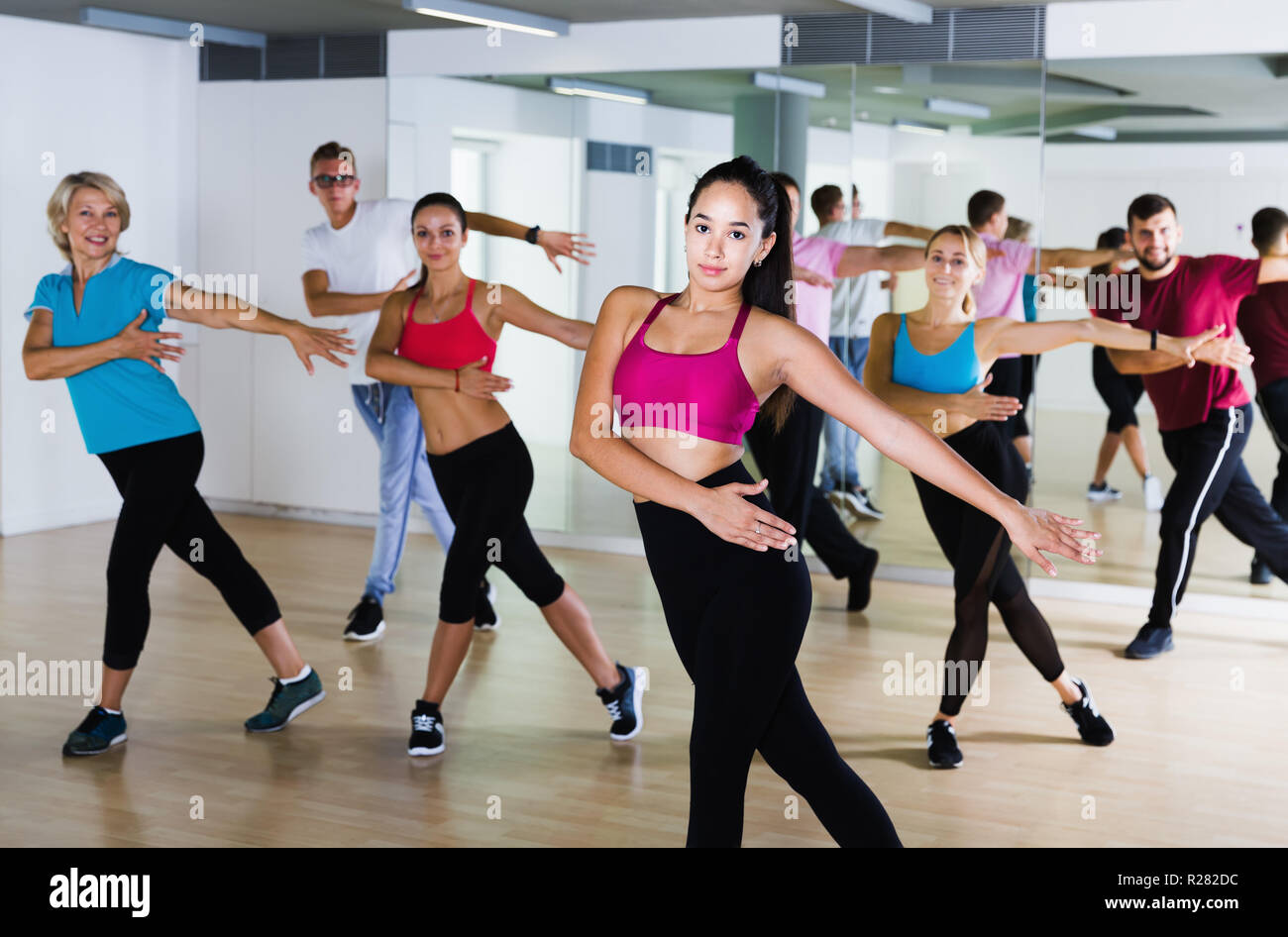 Positive active women and men of different ages dancing in studio Stock ...