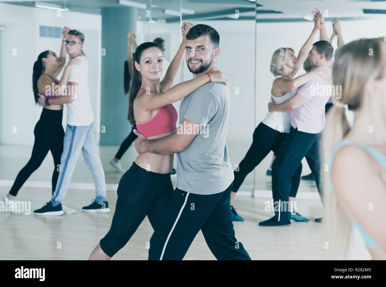 Group of happy smiling adults dancing salsa in club Stock Photo - Alamy