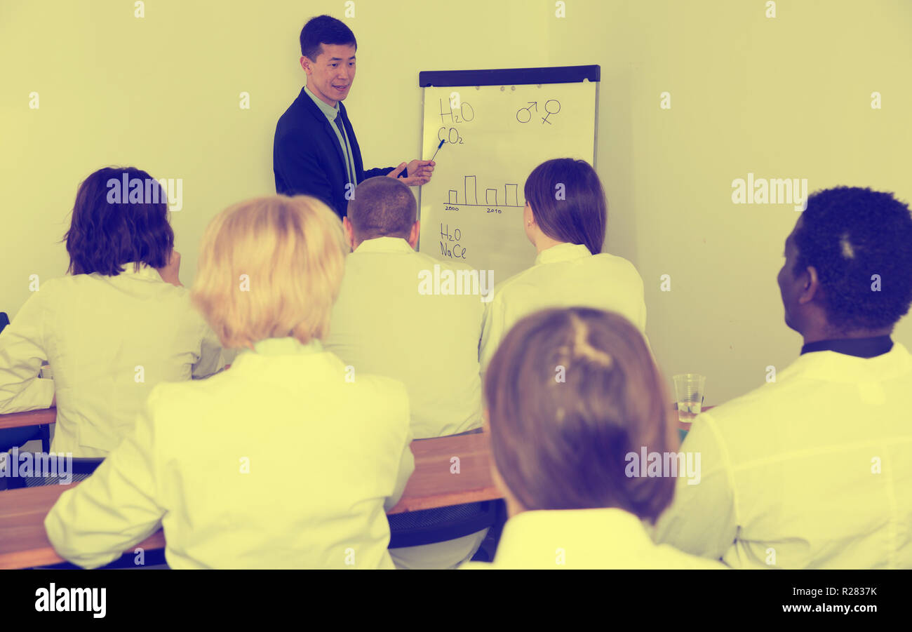 Smiling young male professor giving presentation for medics in ...