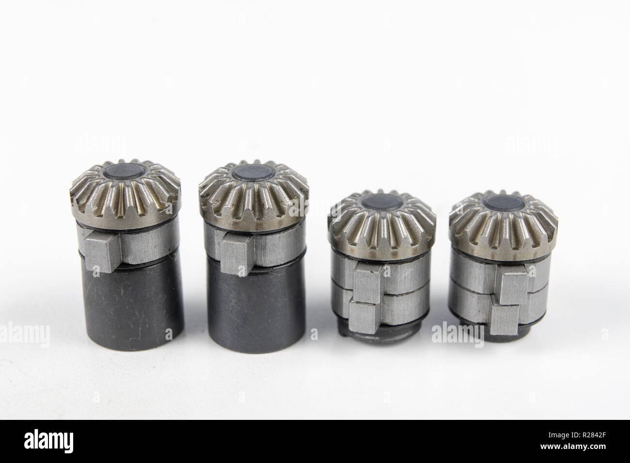Wheels for mechanical gears on a white workshop table. Mechanical parts ...