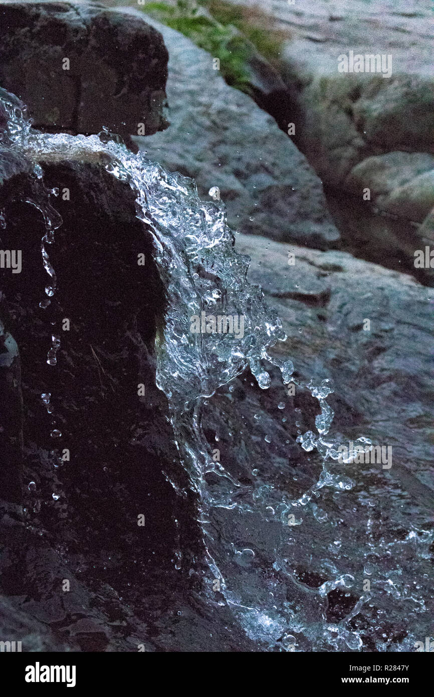 This is a still photo of a mini waterfall moving with its water moving ...