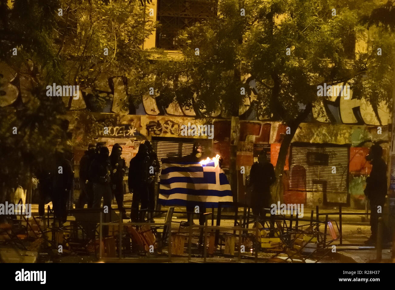 Athens, Greece. 17th Nov 2018. Protesters set a Greek flag on fire ...