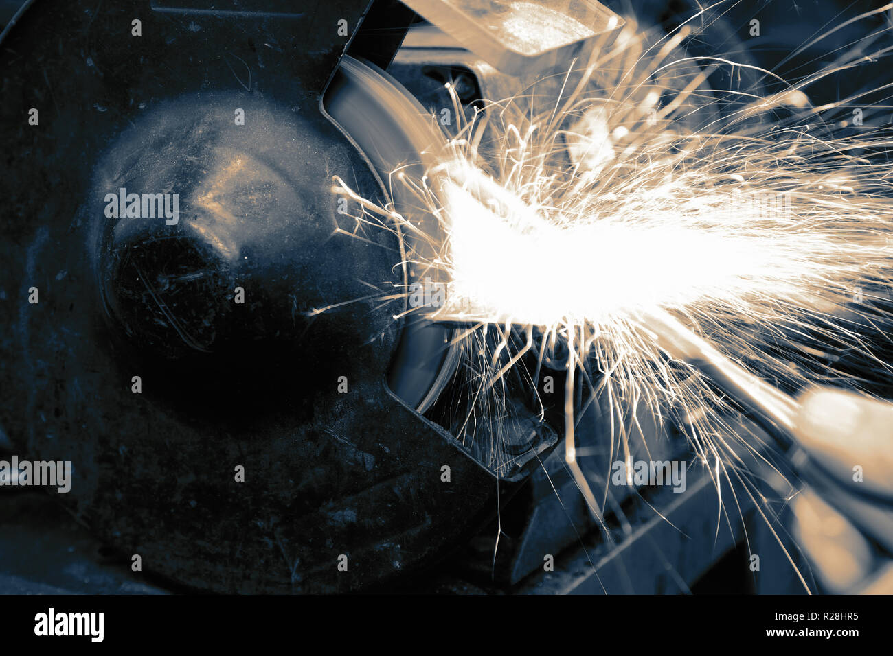 Grinding metal with an electric grinder machine with sparks in a ...