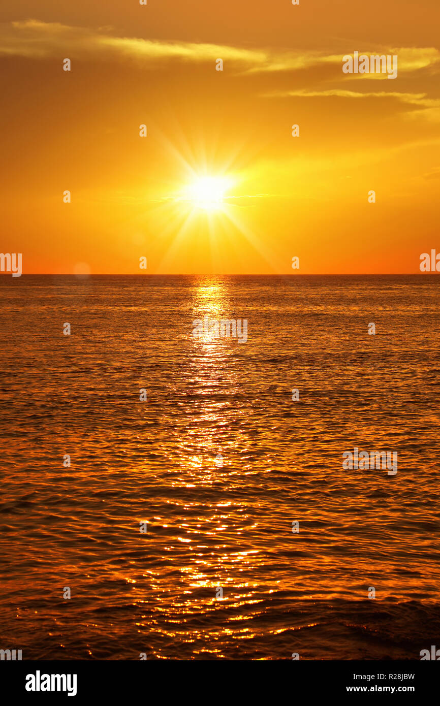 Colorful empty seascape with shiny sea over cloudy sky and sun during ...