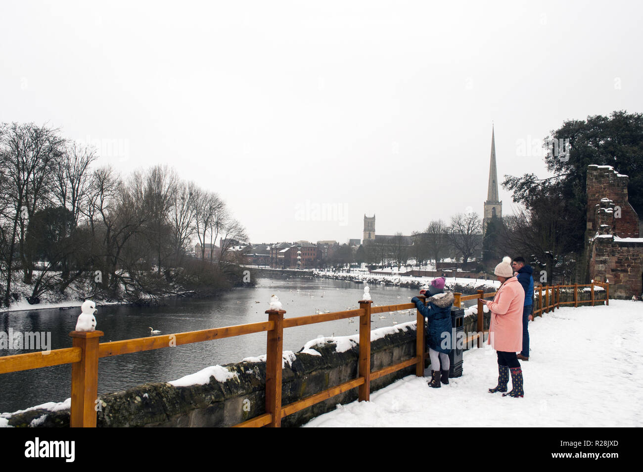 A family is looking at the snow scenery of the riverside in a very cold ...