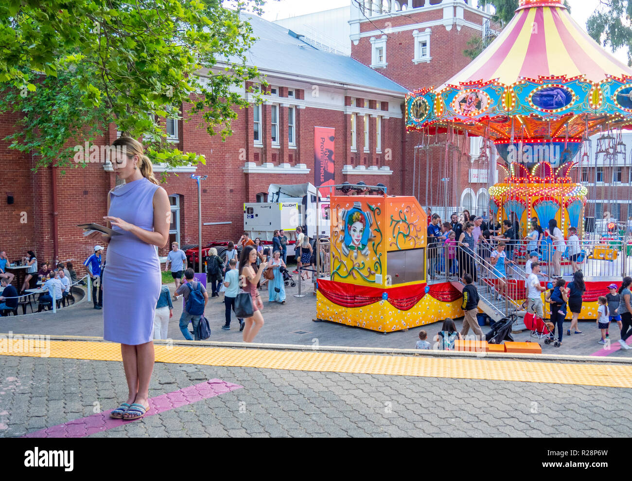 Female television presenter standing by carousel in Perth Cultural ...