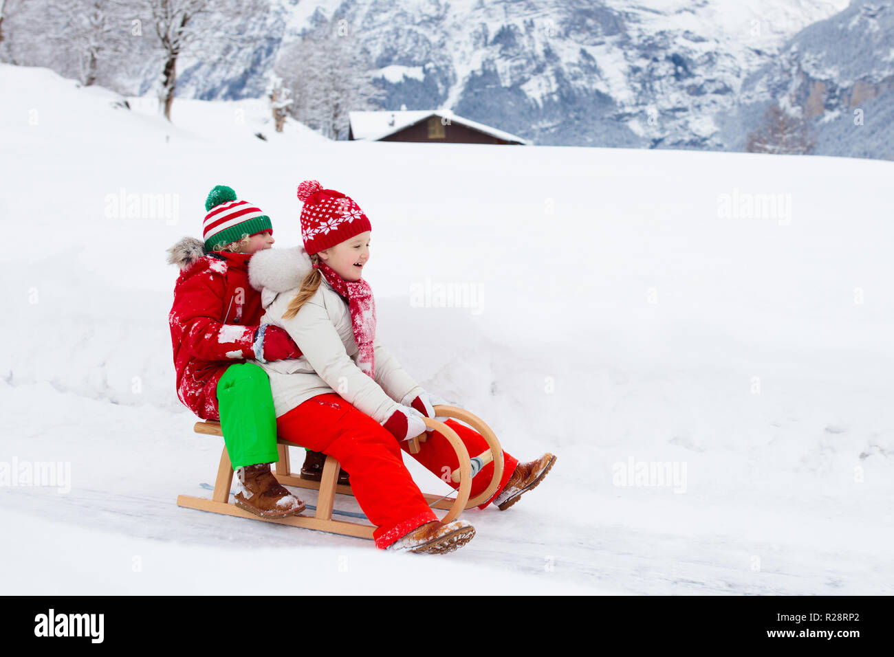 Little girl and boy enjoying sleigh ride. Child sledding. Toddler kid ...