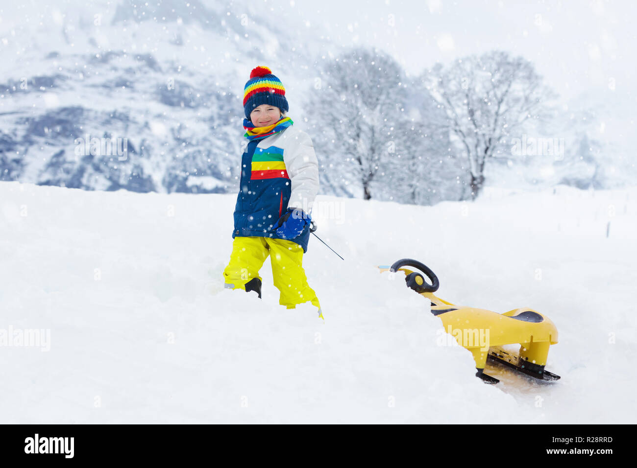 Little boy enjoying a sleigh ride. Child sledding. Toddler kid riding a ...