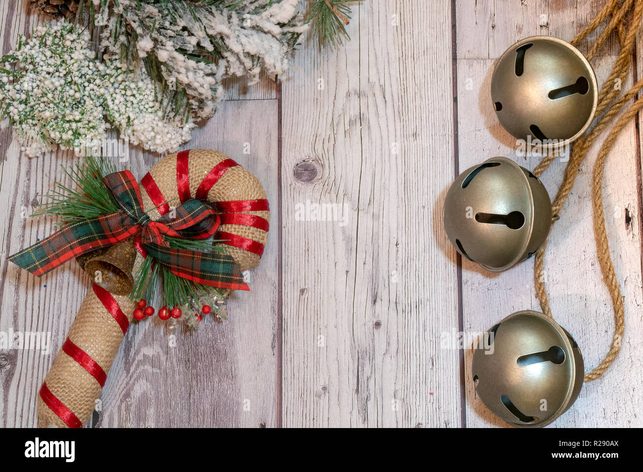 Jingle bells on rope with decorative flocked snow pine branches and a ...
