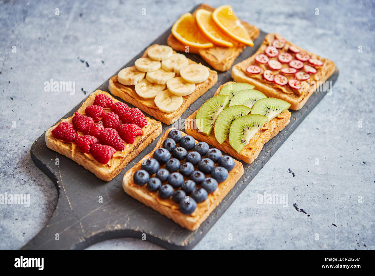 Wholegrain bread slices with peanut butter and various fruits Stock ...