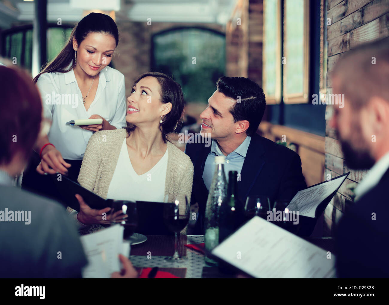 female the waiter recommends dishes to visitors of restaurant Stock ...
