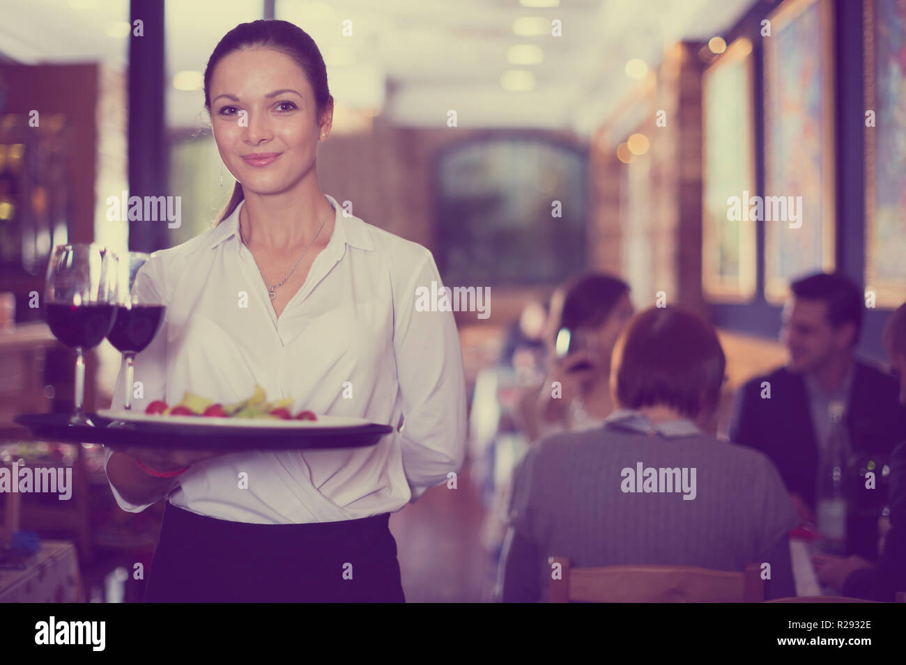 Young positive waitress meeting hi-res stock photography and images - Alamy