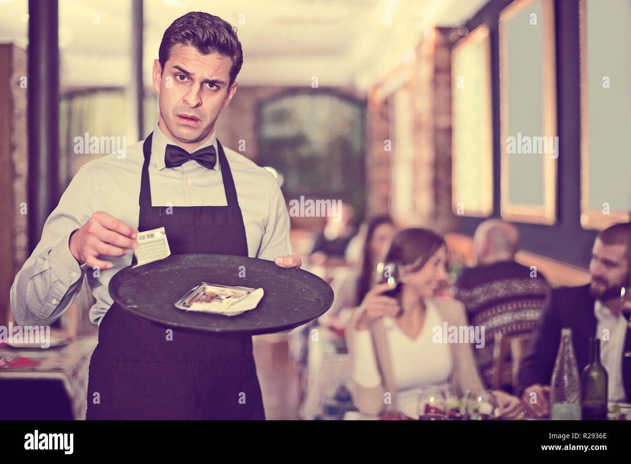 Shocked waiter keeps money to order in a restaurant Stock Photo - Alamy
