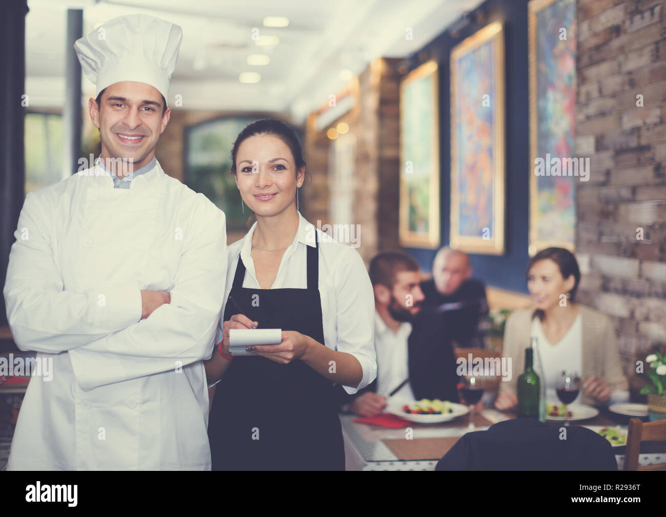 Portrait of smiling waitress with professional chef at a restaurant ...