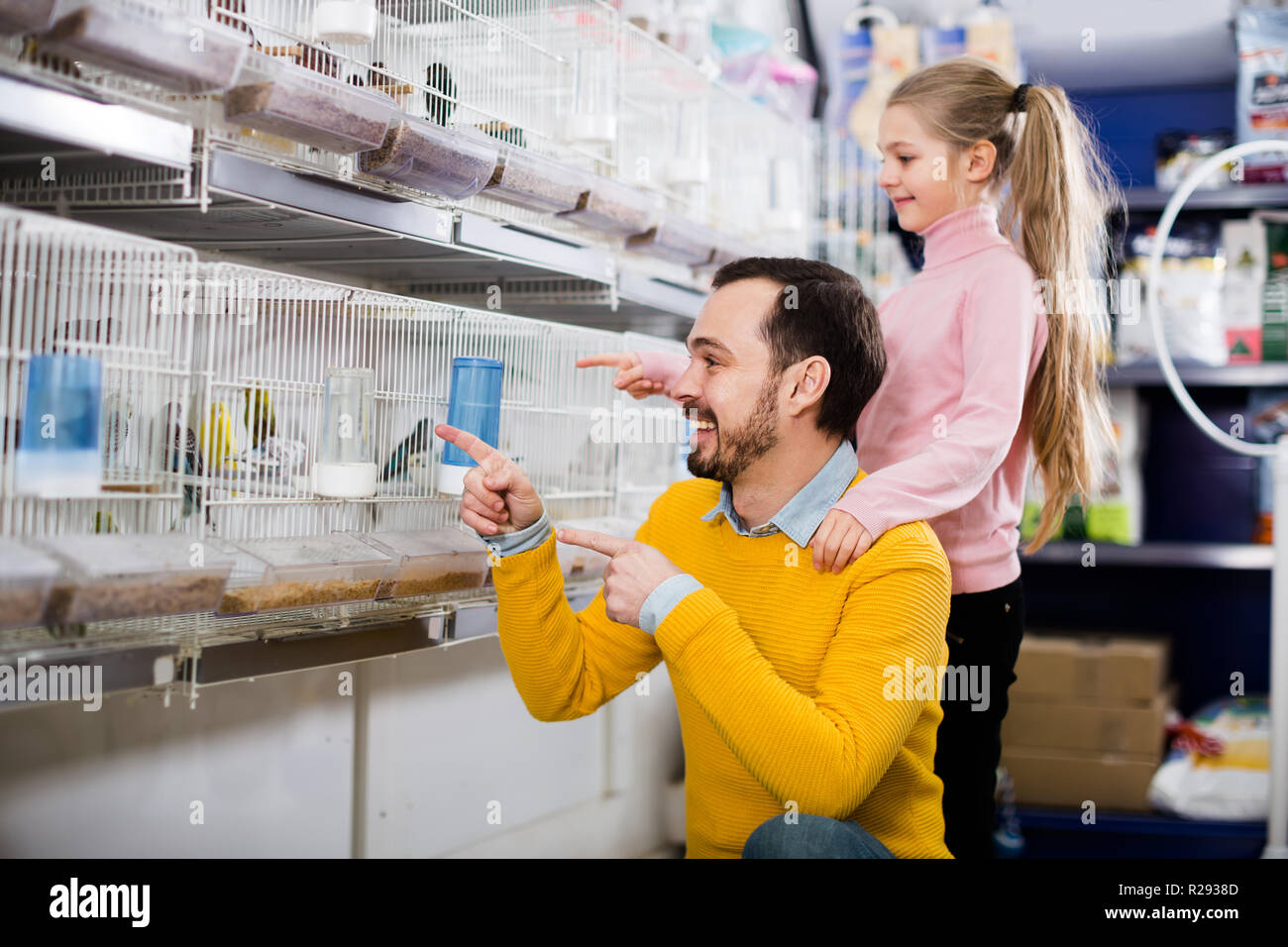 Smiling father showing his daughter species of birds in the store Stock ...