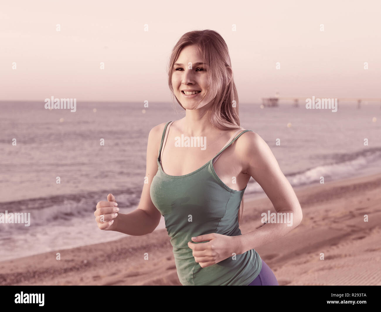 Sportswoman is jogging on the beach near the ocean Stock Photo - Alamy