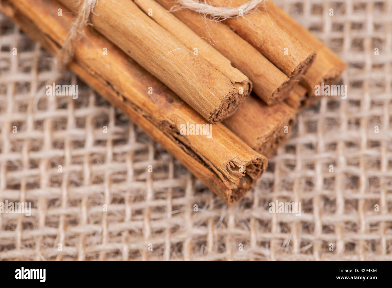 Cinnamon sticks tied with jute rope on burlap background Stock Photo ...