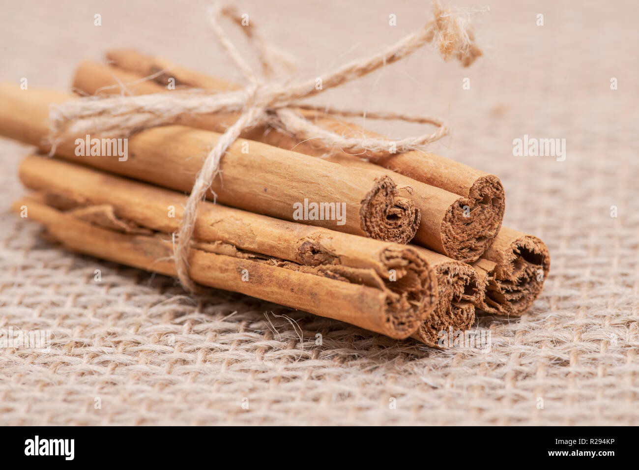 Cinnamon sticks tied with jute rope on burlap background Stock Photo ...
