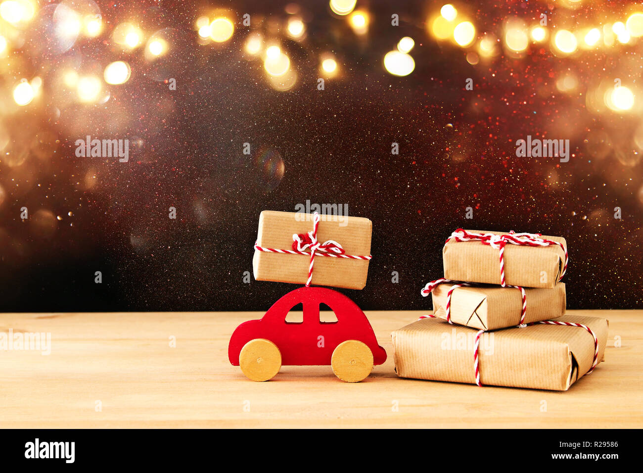 Wooden red car carrying a christmas gift Stock Photo - Alamy