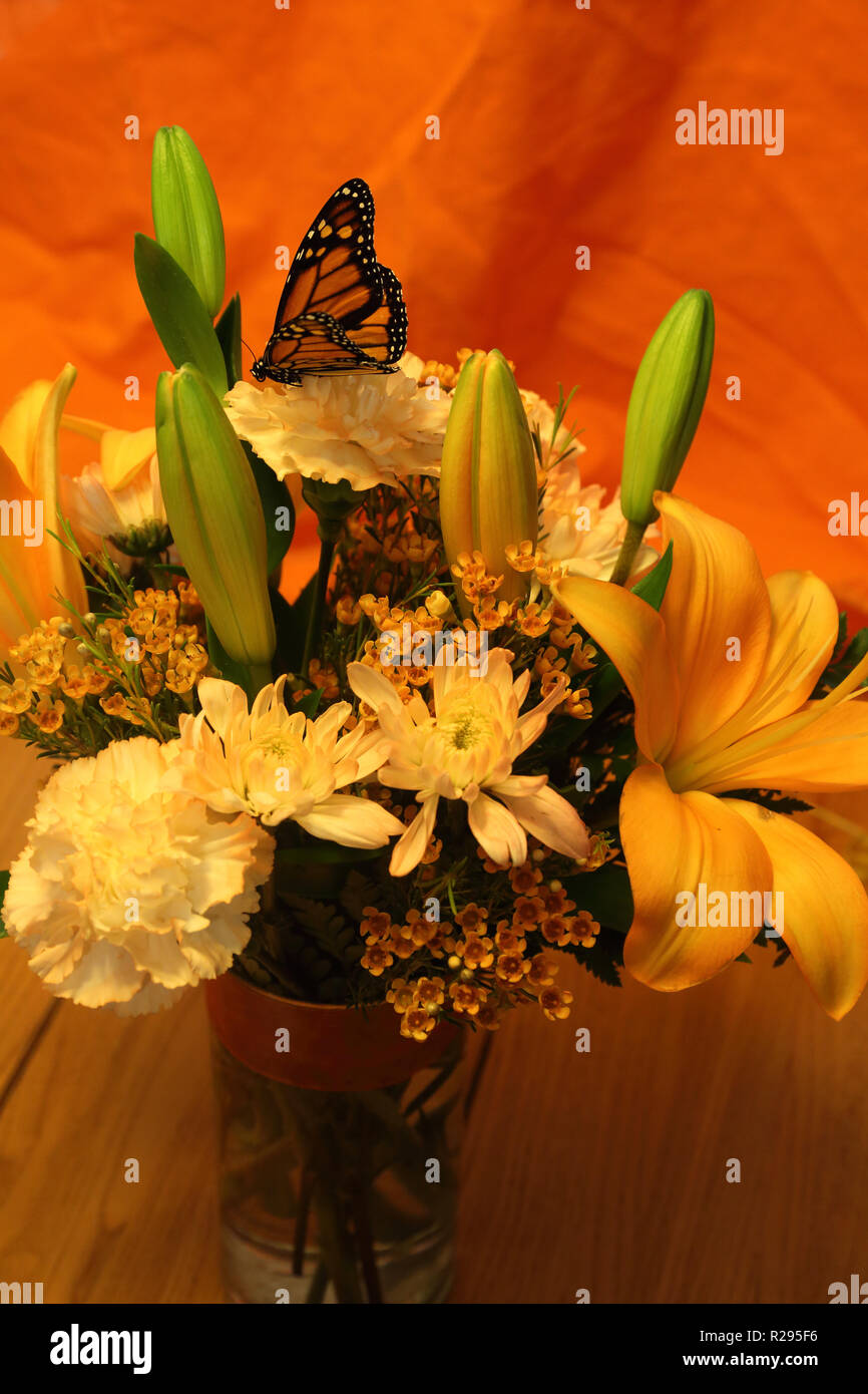 Bouquet of lilies and carnations with a Monarch butterfly and orange ...