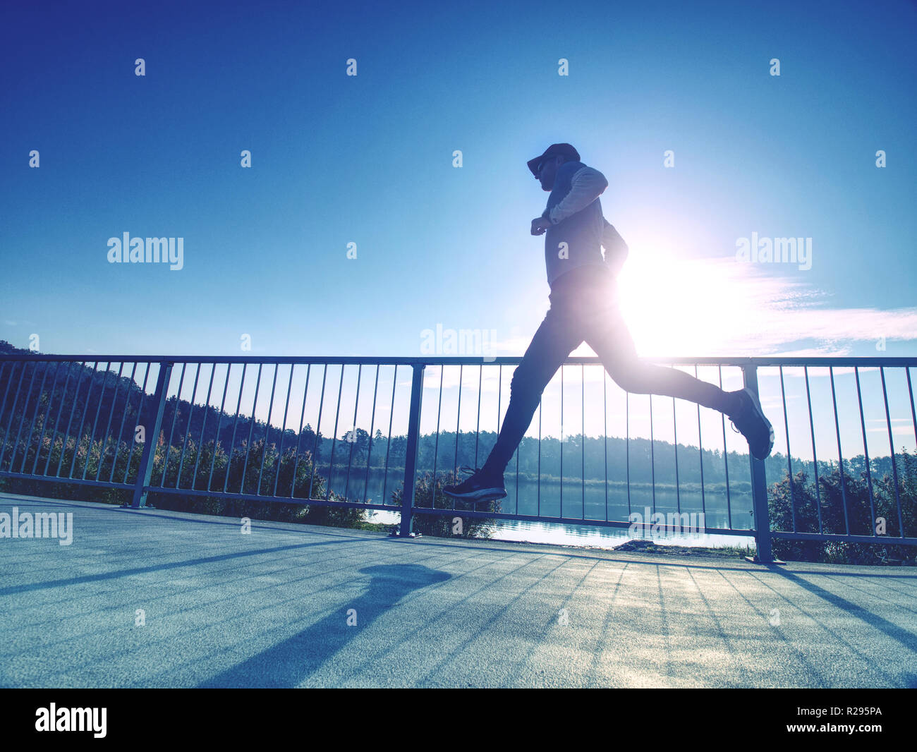 Sporty man run up the bridge . Sport and lifestyle concept - slim man ...