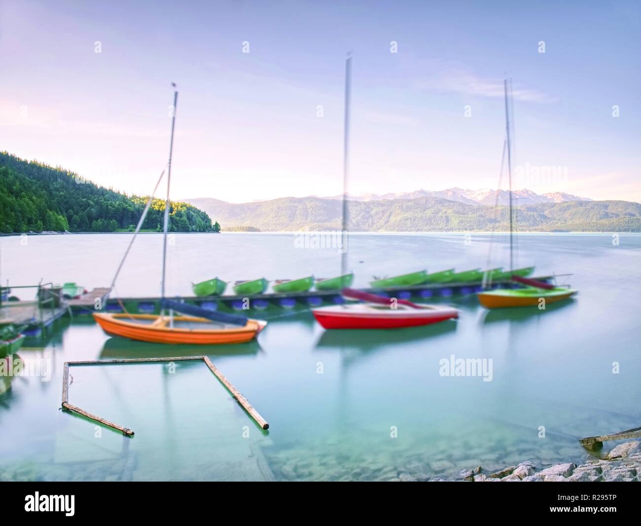 Warm afternoon in soft green and blue light and canoe in lake. Mountain ...