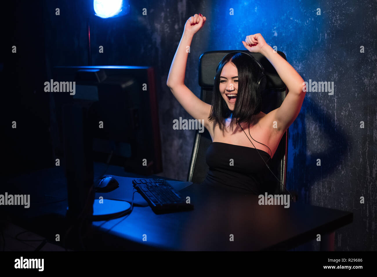 Portrait of a young happy girl who rejoices after winning a video game ...