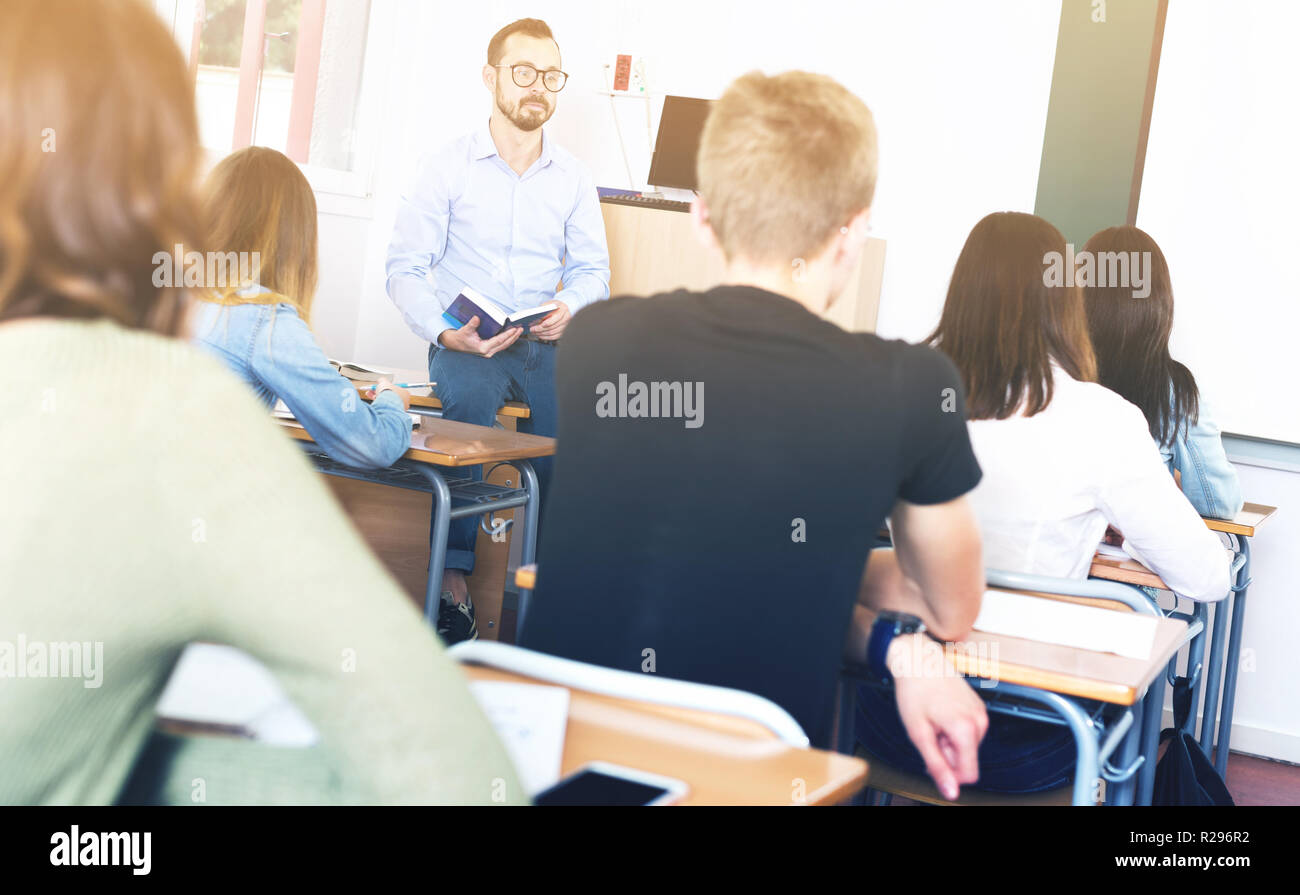 Male teacher is giving interesting lecture for students in the ...