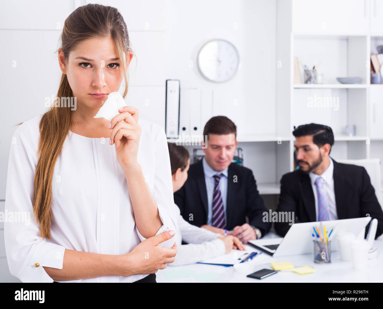 Unhappy and crying woman standing at office on background with ...