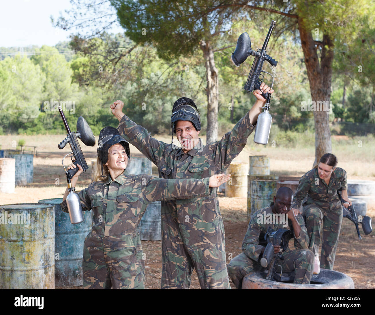Two cheerful paintball players delighted with their winning in game ...