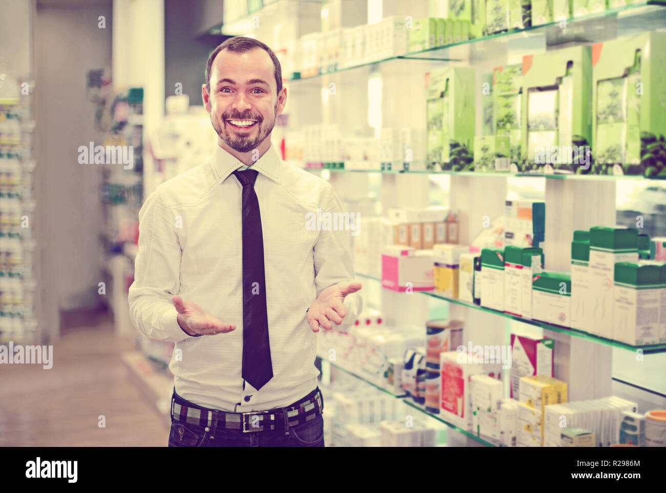 Smiling cheerful positive male customer looking for right medicine in ...