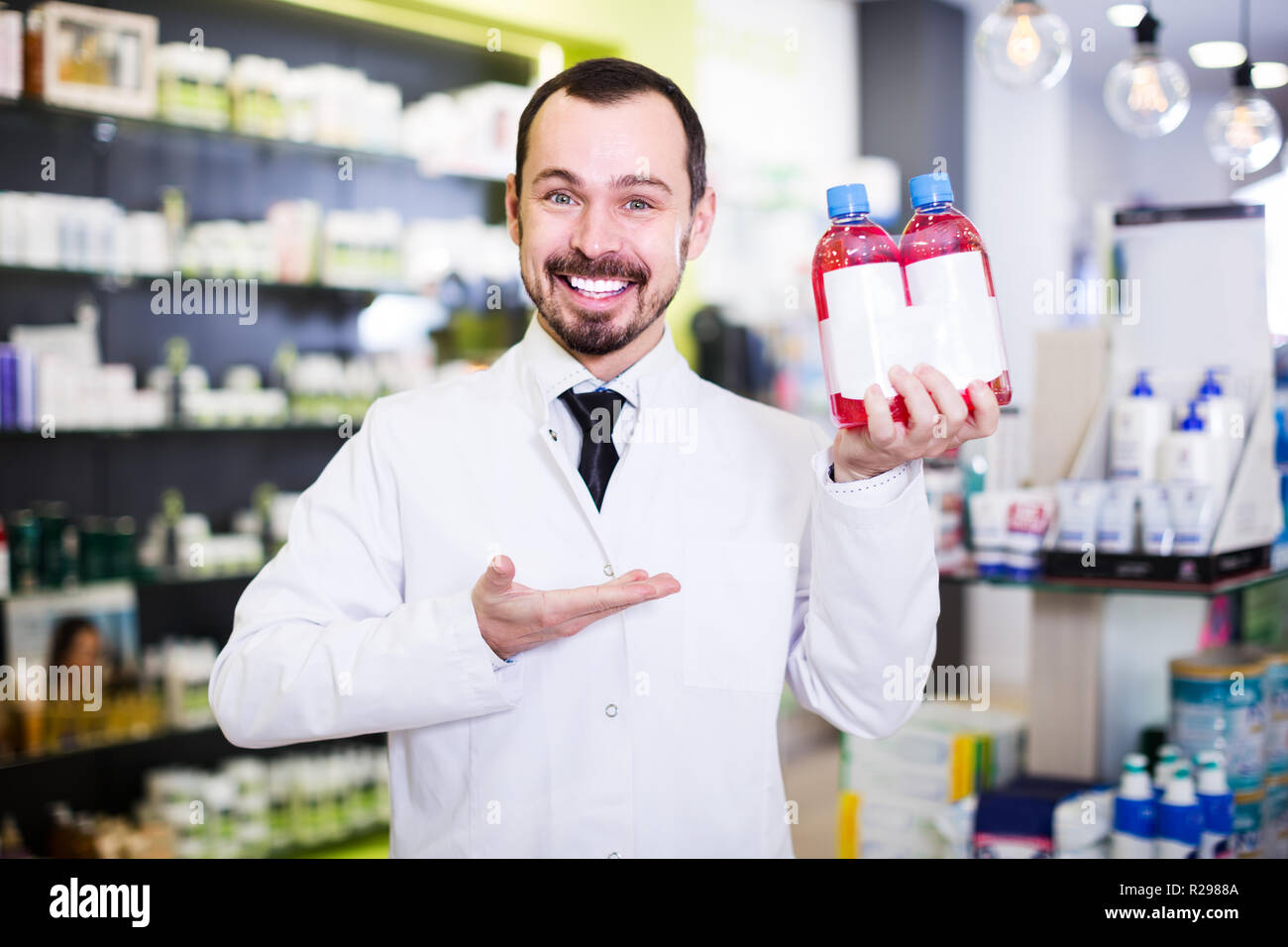 Positive male pharmacist offering reliable drugs in drugstore Stock ...