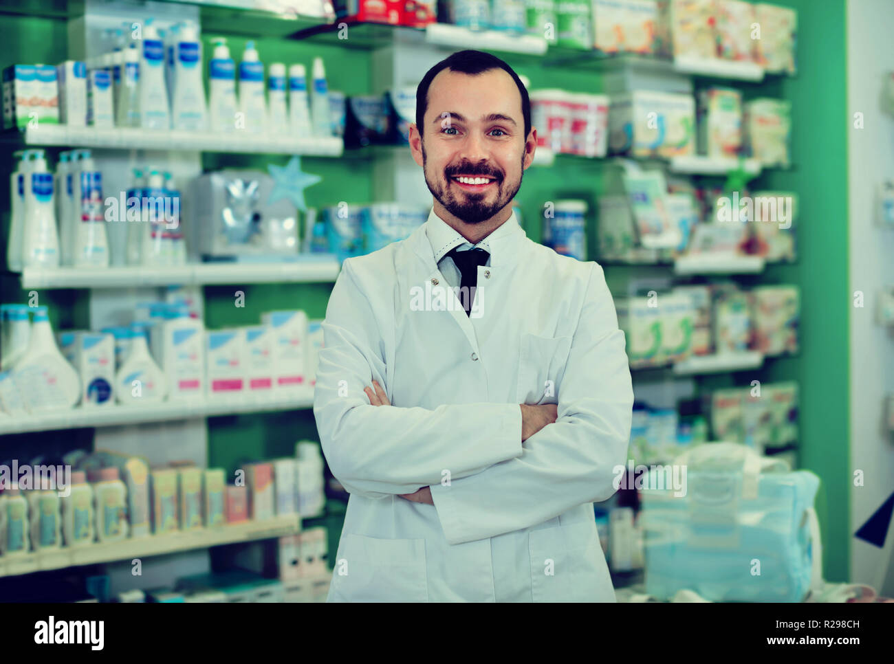 Happy cheerful positive male pharmacist demonstrating assortment of ...