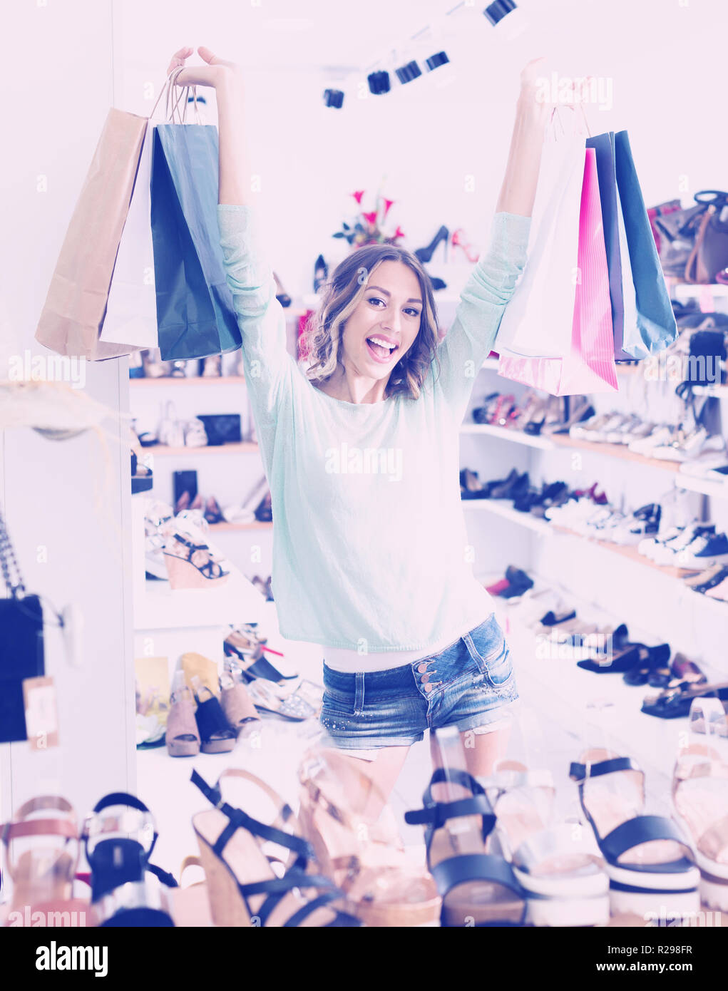 Positive girl is showing purchases in shoes shop Stock Photo - Alamy