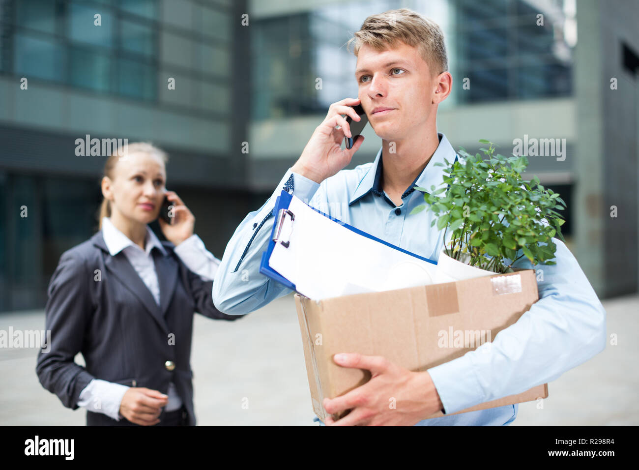 Office worker is talking phone about the new job outside the office ...