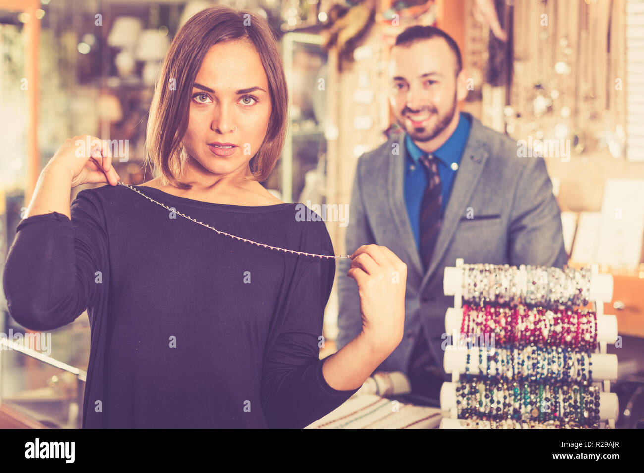Adult buyer woman choosing chainlet and pendants in the jewelry store ...
