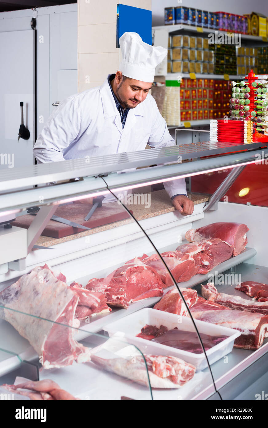 Portrait of smiling european male butcher in kosher section at ...