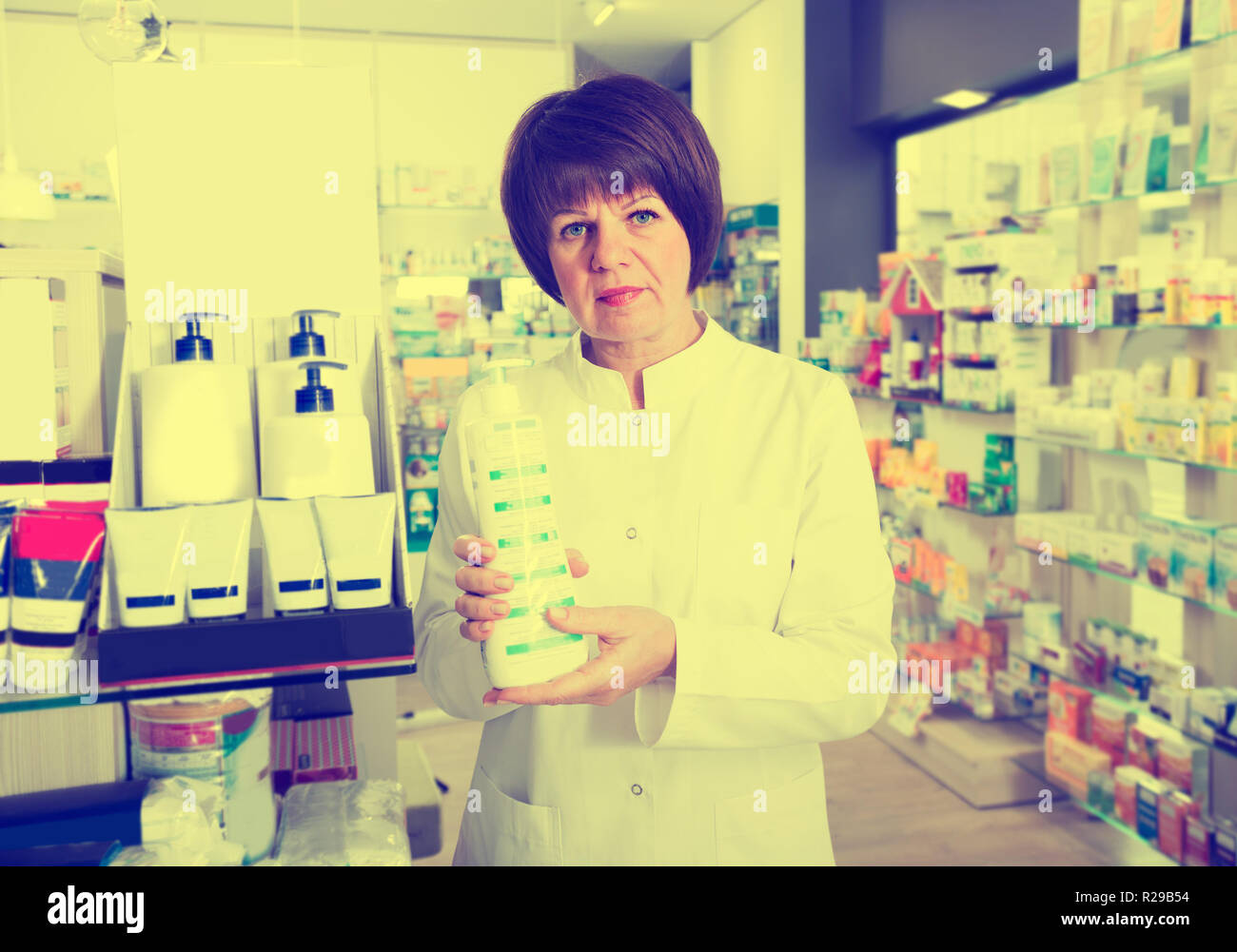 smiling woman pharmacist wearing uniform and working in pharmaceutical ...