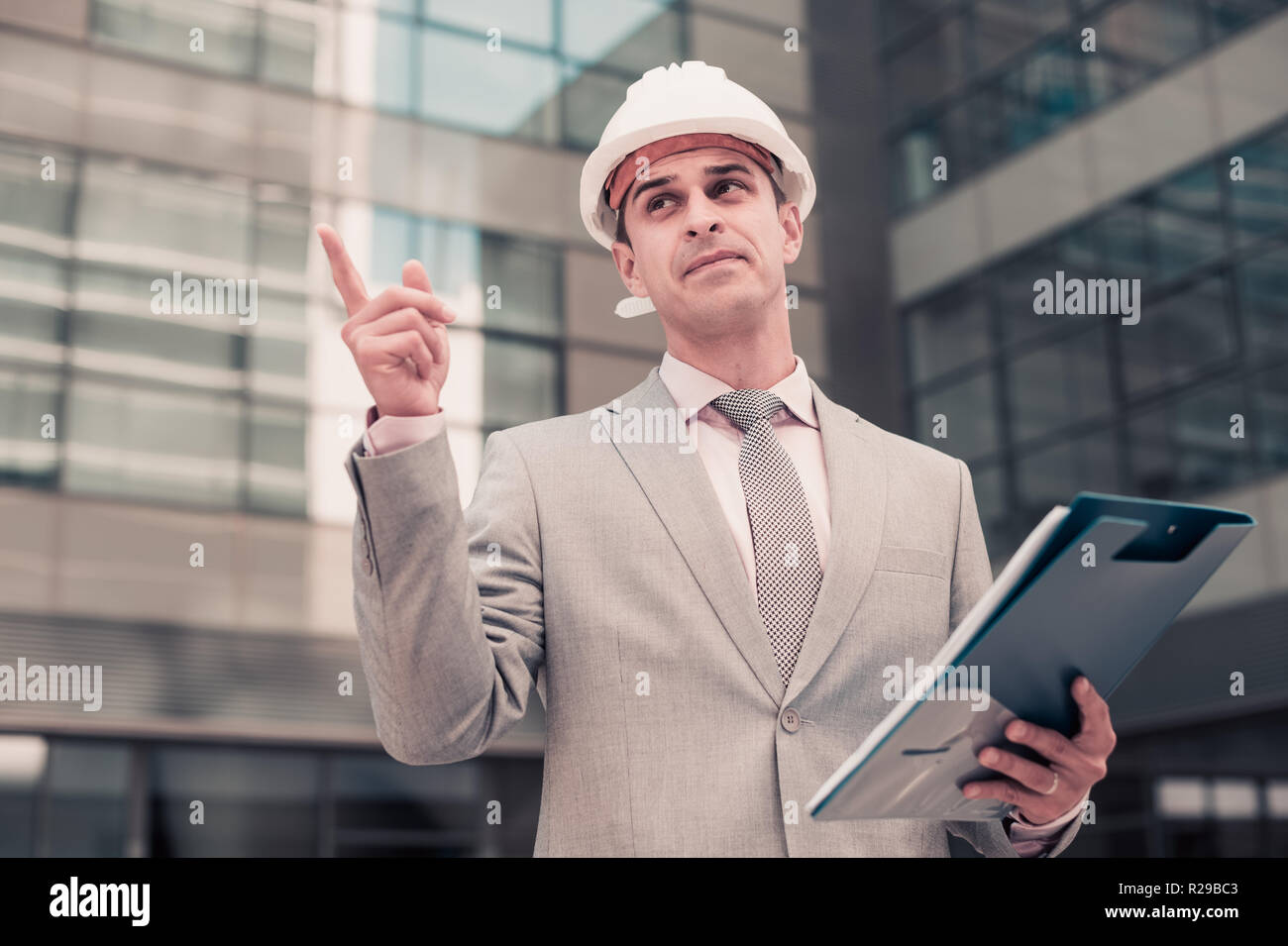 Portrait of manager of plant giving instructions and pointing with his ...
