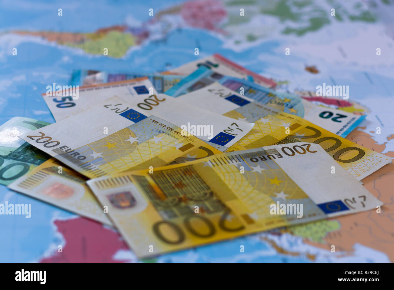 Different euro banknotes on world map. Two hundred, hundred, fifty ...