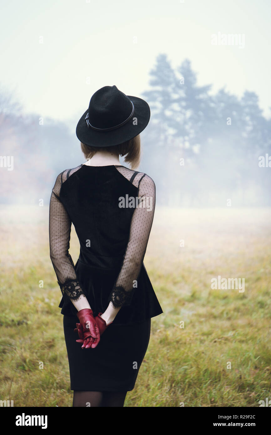 Girl black dress stands back Stock Photo - Alamy