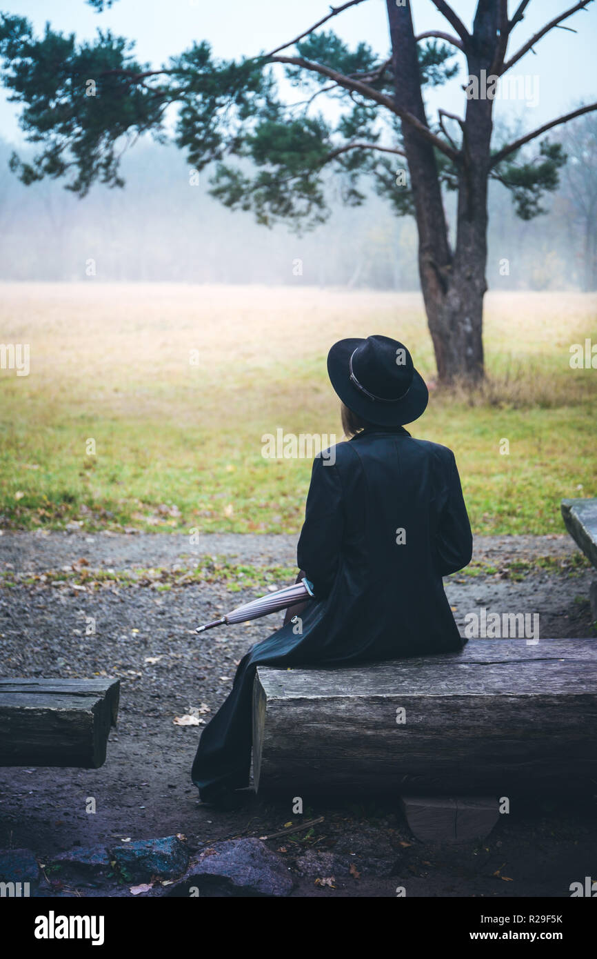 girl sitting on a bench, view from the back Stock Photo - Alamy