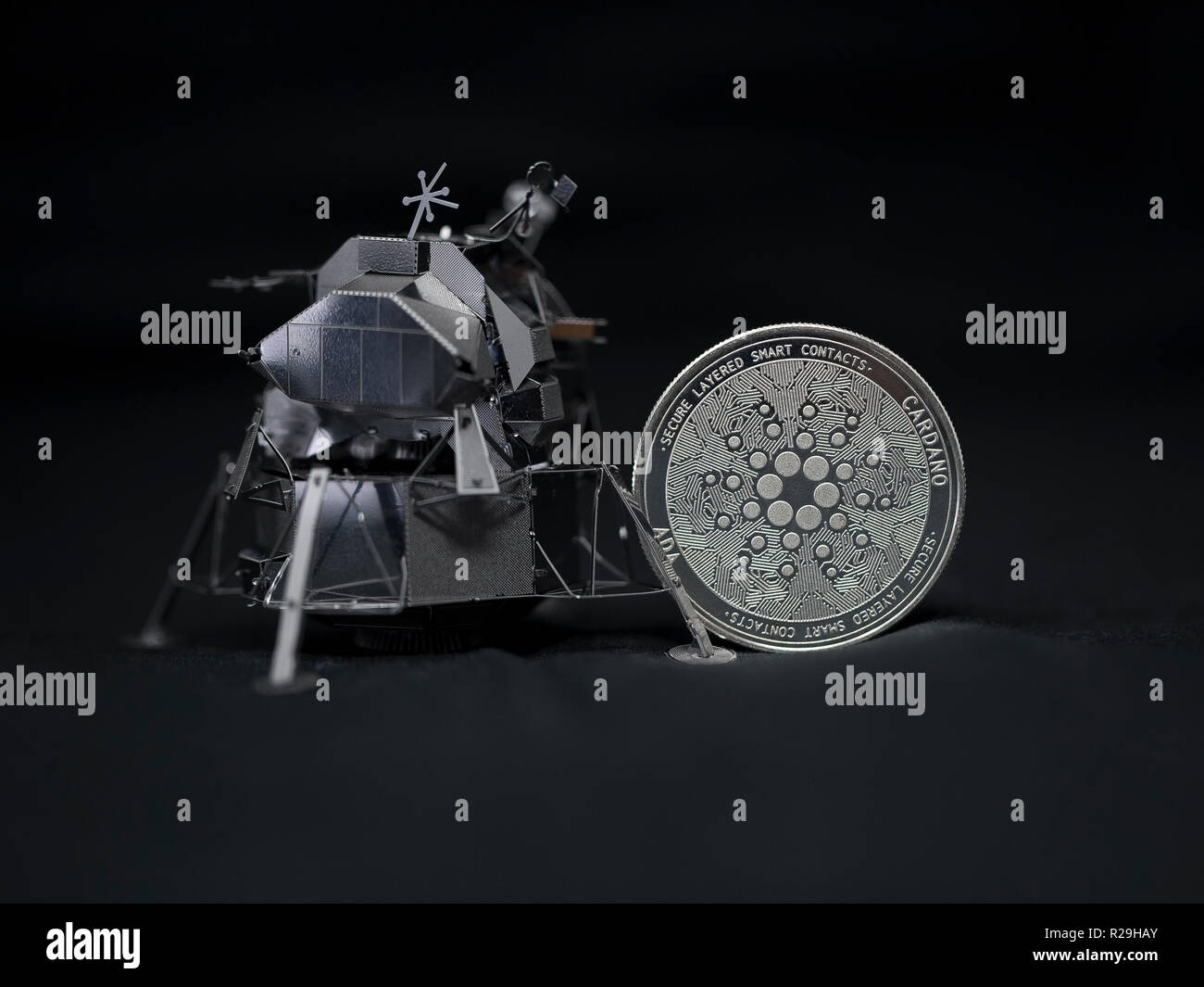 Cardano cryptocurrency physical coin next to moon lander model Stock ...
