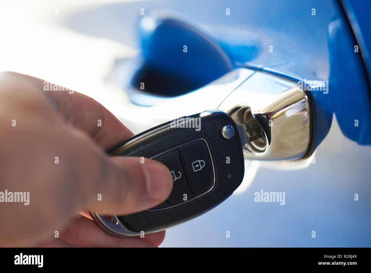 Unlocking blue car door with key close up Stock Photo - Alamy