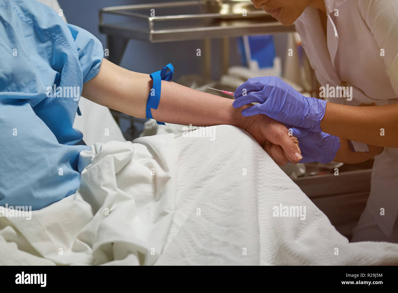 Nurse injecting in vein catheter niddle close-up view Stock Photo - Alamy