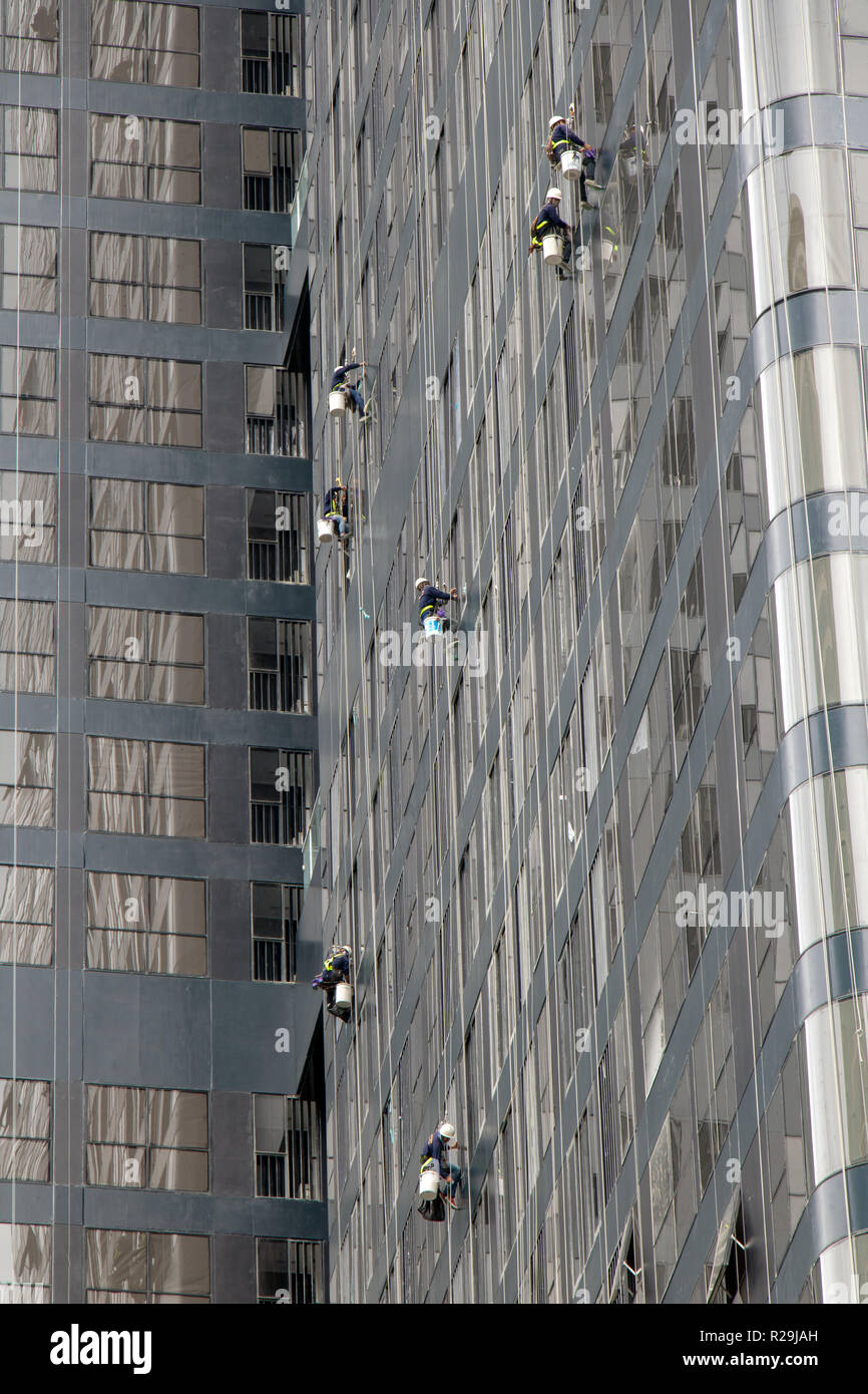 Mens washes glass on high-rise building. Service cleaning the windows ...